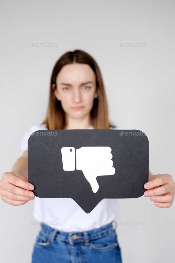 Sad young woman holding Dislike button icon of social media Stock Photo ...