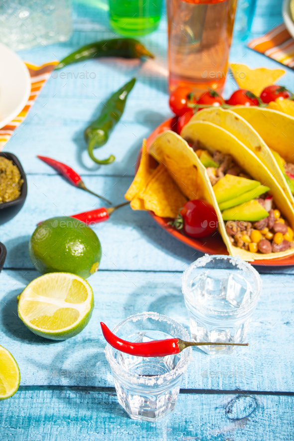 Mexican tequila shots with lime and hot red chili with traditional food ...