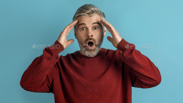 Shocked appalled middle aged man gesturing on blue background Stock ...