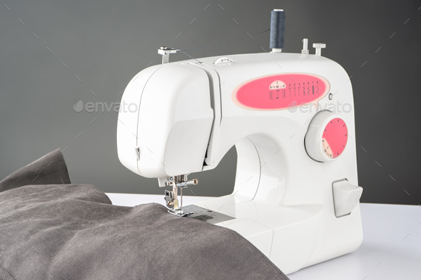 Modern sewing machine with gray fabric Stock Photo by Kateryna_Maksymenko