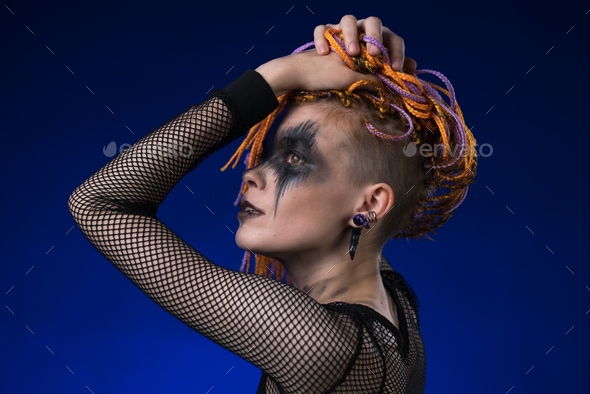 Young woman with orange color braids hairdo and horror black stage make ...
