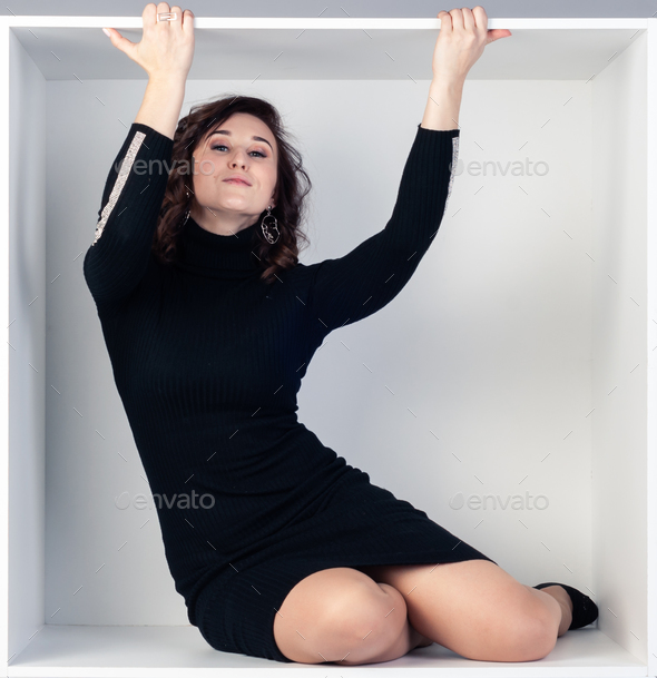 Beautiful portrait of a girl in a white cube sitting Stock Photo by ...