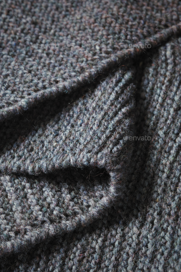 Dark gray knitted fabric folded in a zigzag pattern. Knitted texture ...