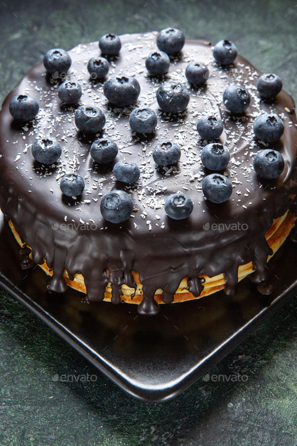 front view delicious chocolate cake with blueberries on dark background ...