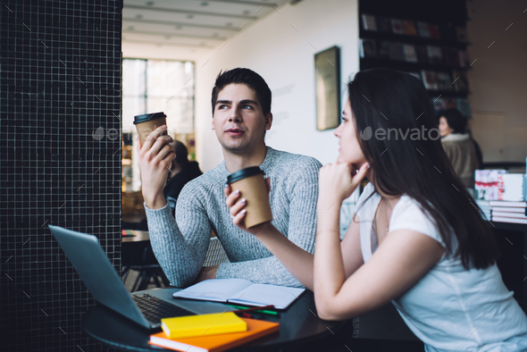 Concentrated coworkers discussing project at workplace with laptop and ...