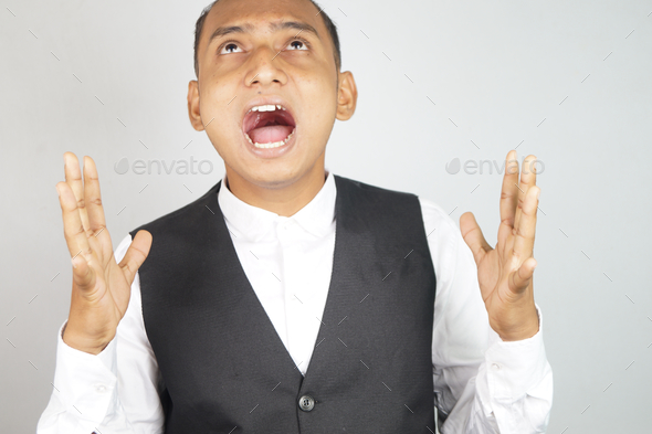 Excited handsome Indian man in formal wear in shock looking up on a ...
