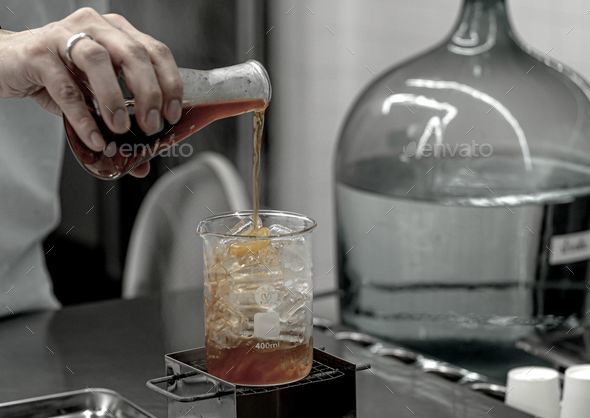 Barista hand holding a Glass Beaker Mixing tea drink beverage In ...