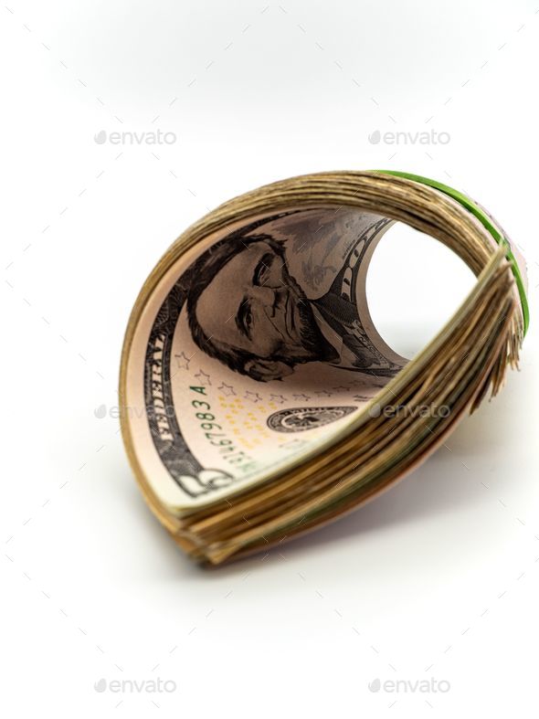 rolled up dollar bills on a white surface Stock Photo by wirestock