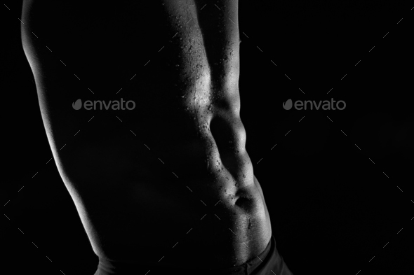 Grayscale shot of a bare torso of a muscular man Stock Photo by wirestock