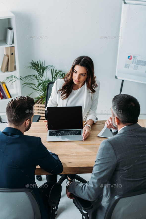 advisor showing to investors laptop with blank screen at workplace ...