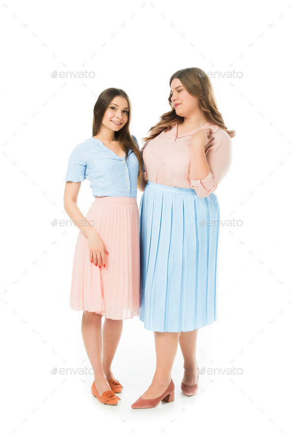 smiling elegant overweight and slim women hugging isolated on white ...