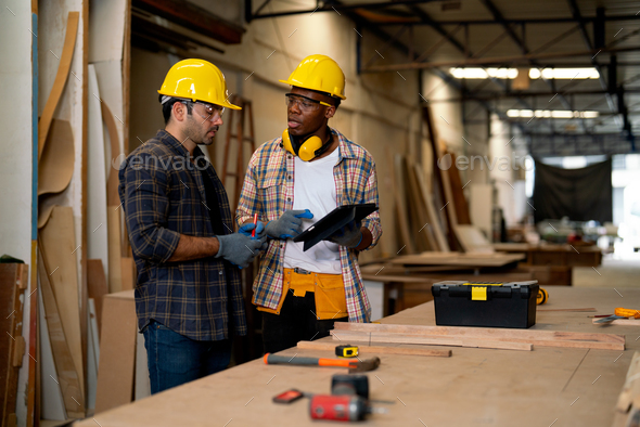 African American and Caucasian carpenter man discuss together about ...