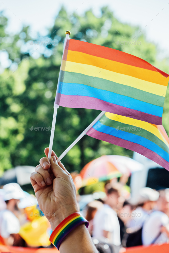 Gay pride, LGBTQ rainbow flags being waved in the air at a pride event ...
