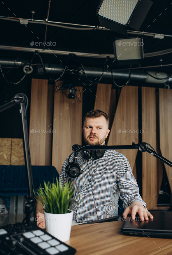 Portrait of smiling hispanic male radio presenter with clipboard ...