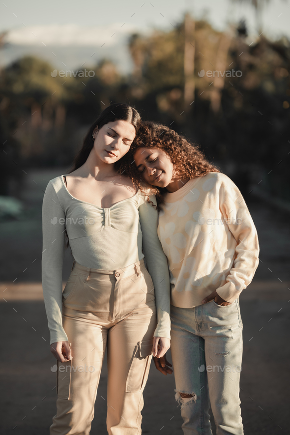 Two women standing relaxed together with eyes closed outdoors Stock ...