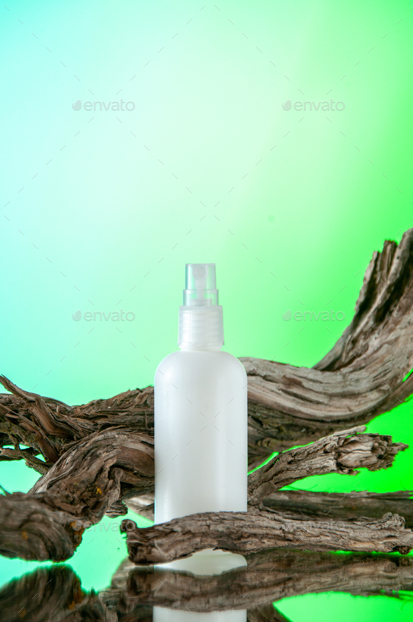 front view spray bottle tree branch on light green background Stock ...