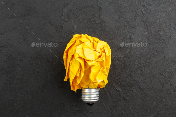 top view light bulb wrapped with paper on black table with free space ...