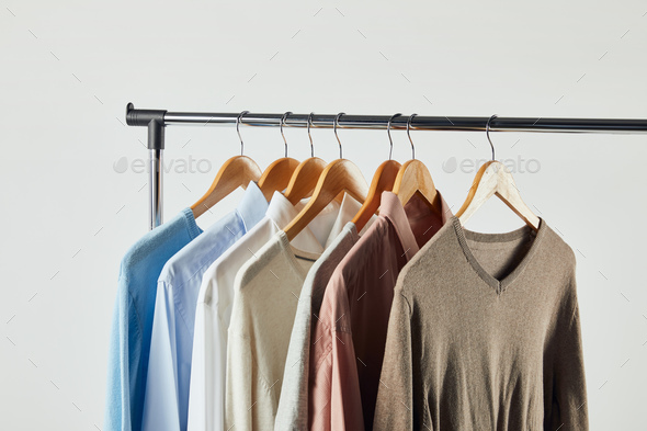 Straight rack, wooden hangers and male clothes isolated on grey Stock ...