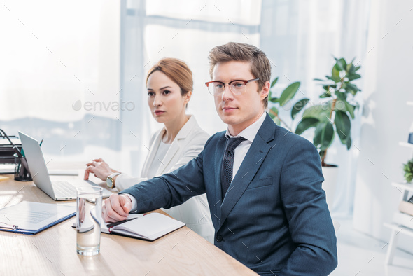 handsome recruiter in glasses sitting with attractive coworker in ...