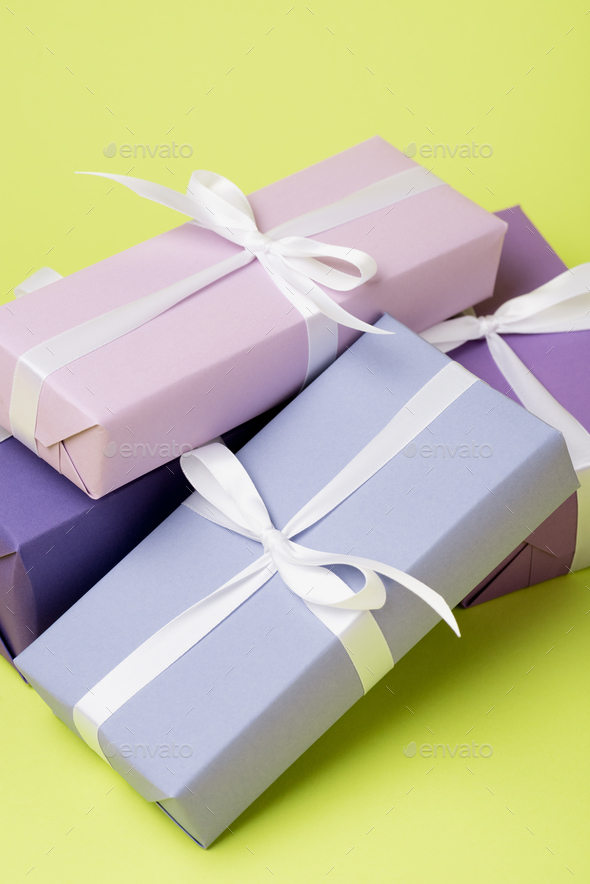purple gift boxes with white ribbons on yellow surface Stock Photo by ...