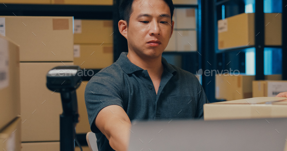 Close-up Asian man use barcode machine scan data in box and register ...