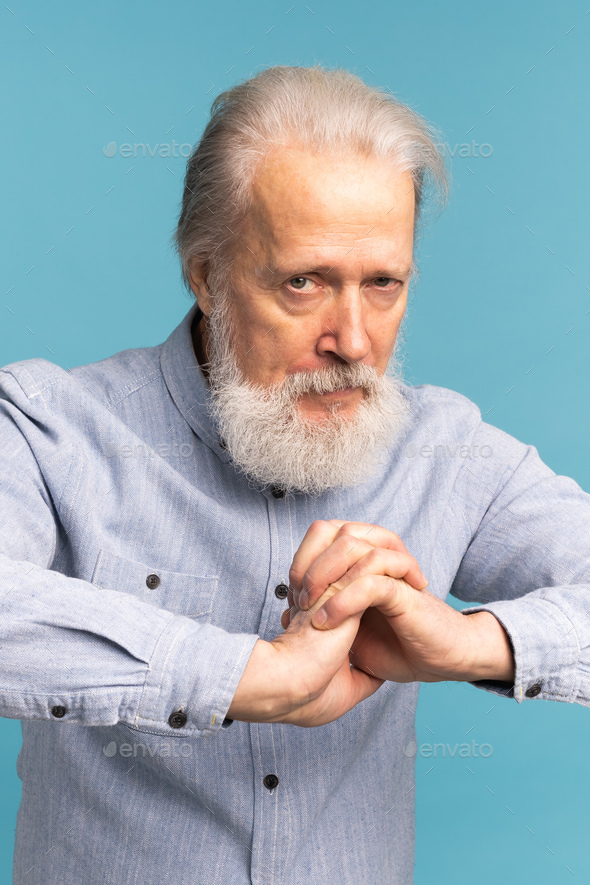 Portrait of angry pissed off bad senior mature man on blue background ...