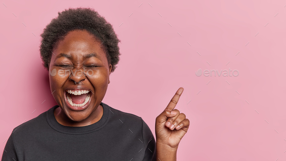 Emotional dark skinned woman with plump face exclaims loudly keeps ...