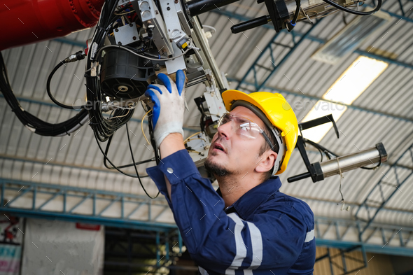 Robotic Arm engineer check on equipment in its with software of ...