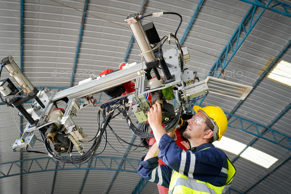 Robotic Arm engineer check on equipment in its with software of ...