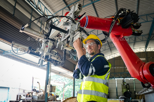 Robotic Arm engineer check on equipment in its with software of ...