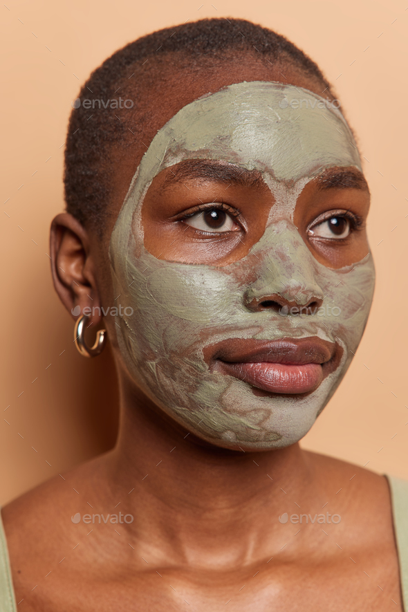 Close up shot of serious female model with short hairstyle stands ...