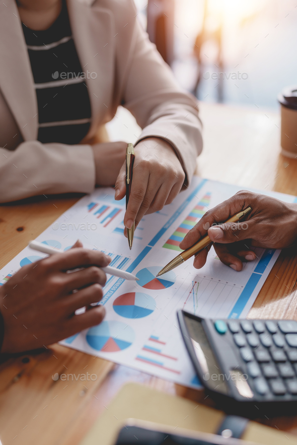 Business people meeting pointing graph and chart to analyze financial ...