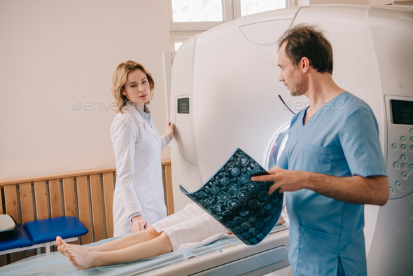doctor holding tomography diagnosis while radiologist operating ct ...