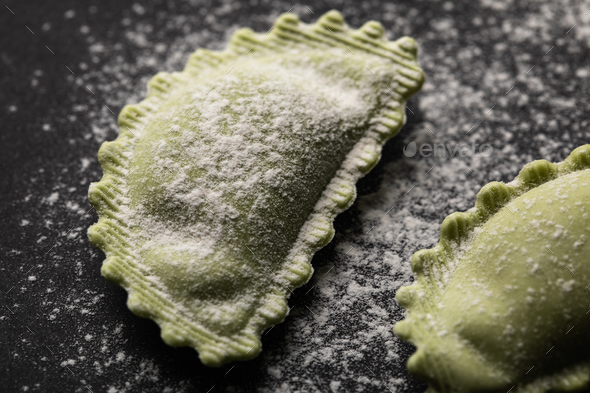 close up view of green fresh ravioli with flour on black surface Stock ...
