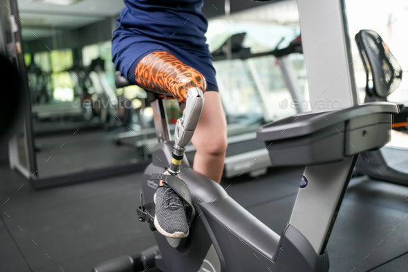 Disabled athlete with leg prosthesis training at the gym. Paralympic ...