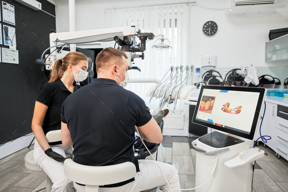 Dentist scanning patient's teeth with modern machine for intraoral ...