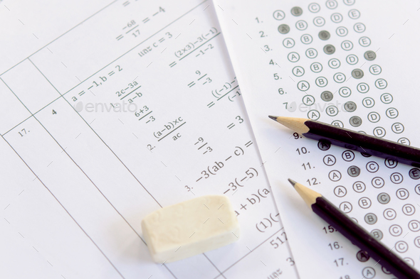 Pencil and eraser on answer sheets or Standardized test form with ...