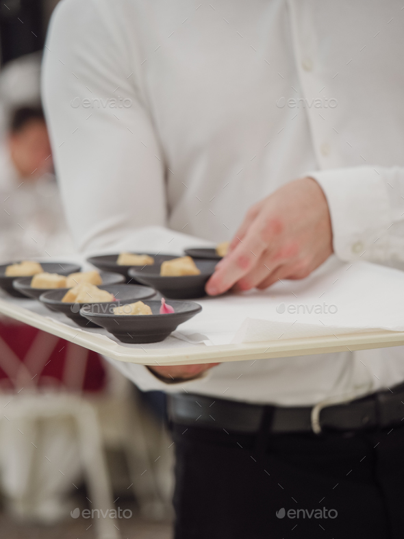 waiter serving luxury finger food in event buffet - catering staff at ...