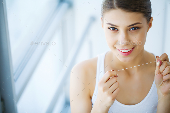 Teeth Care. Beautiful Smiling Woman Flossing Healthy White Teeth. High ...
