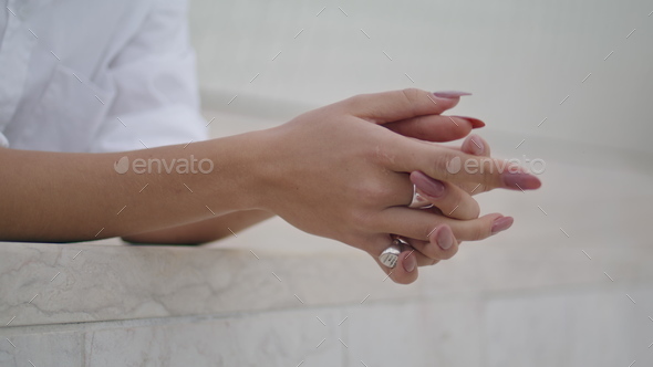 Woman hands crossing fingers with stylish ring close up. Arms with nude ...