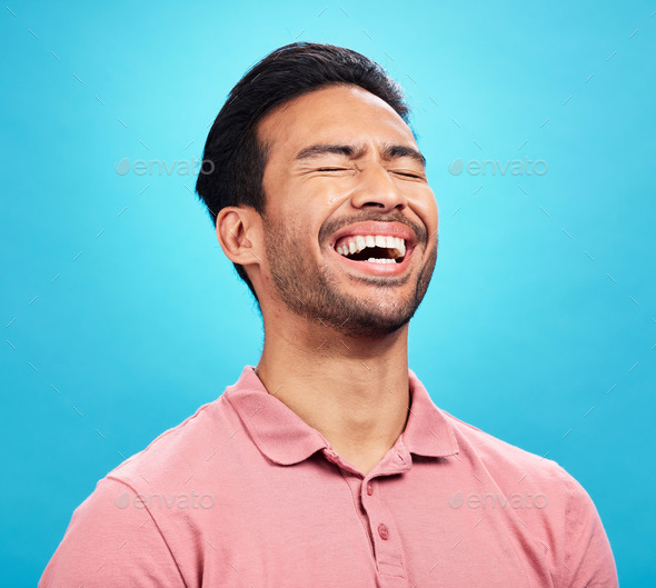 Laughing, funny comedy and man in studio isolated on a blue background ...