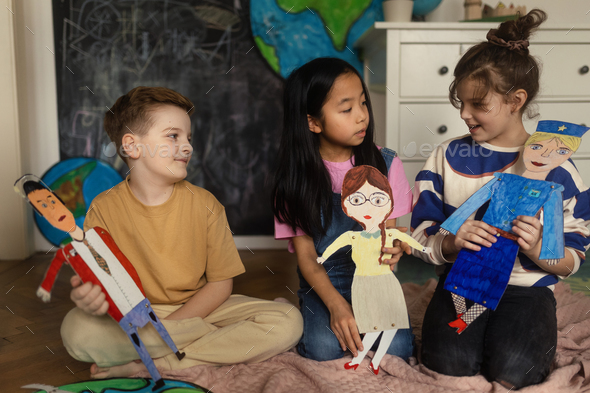 Little children playing with a handmade puppets. Stock Photo by halfpoint