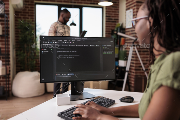 African american software developer debugging source code algorithm looking at computer screen ...