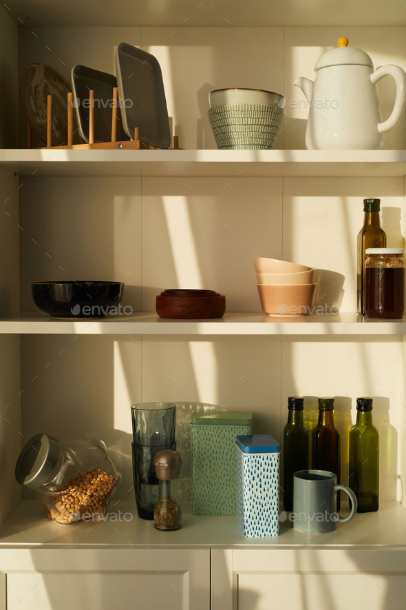 Cupboard with kitchen utensils on the shelves Stock Photo by ...