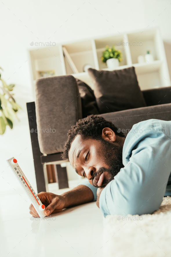 exhausted african american man suffering from summer heat while lying ...