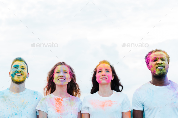 positive multicultural friends with holi paints on faces Stock Photo by ...