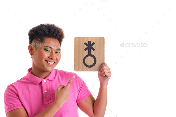 gender non-binary asian person pointing to a sign with gender queer ...