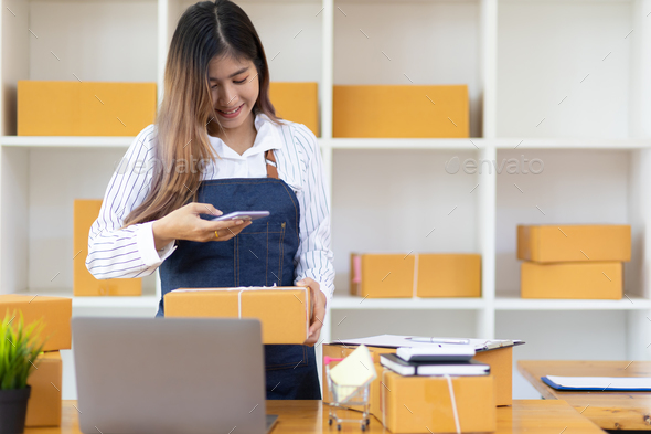 Female small business owner using mobile app on smartphone scanning ...