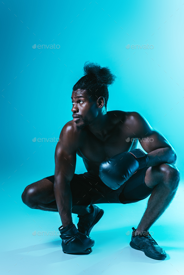 handsome, african american boxer looking away while posing at camera on ...