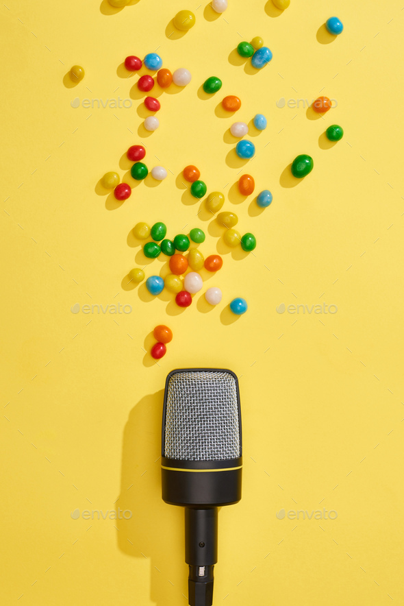 top view of microphone with candies on bright and colorful background ...